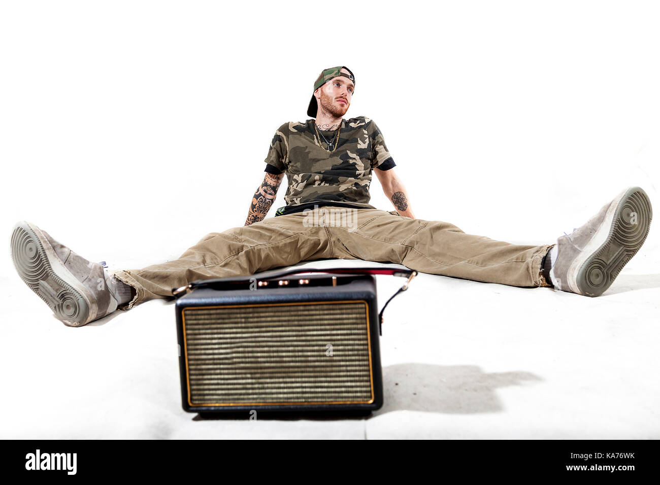 sitting tattooed rap singer posing in studio with an amplified radio on ...