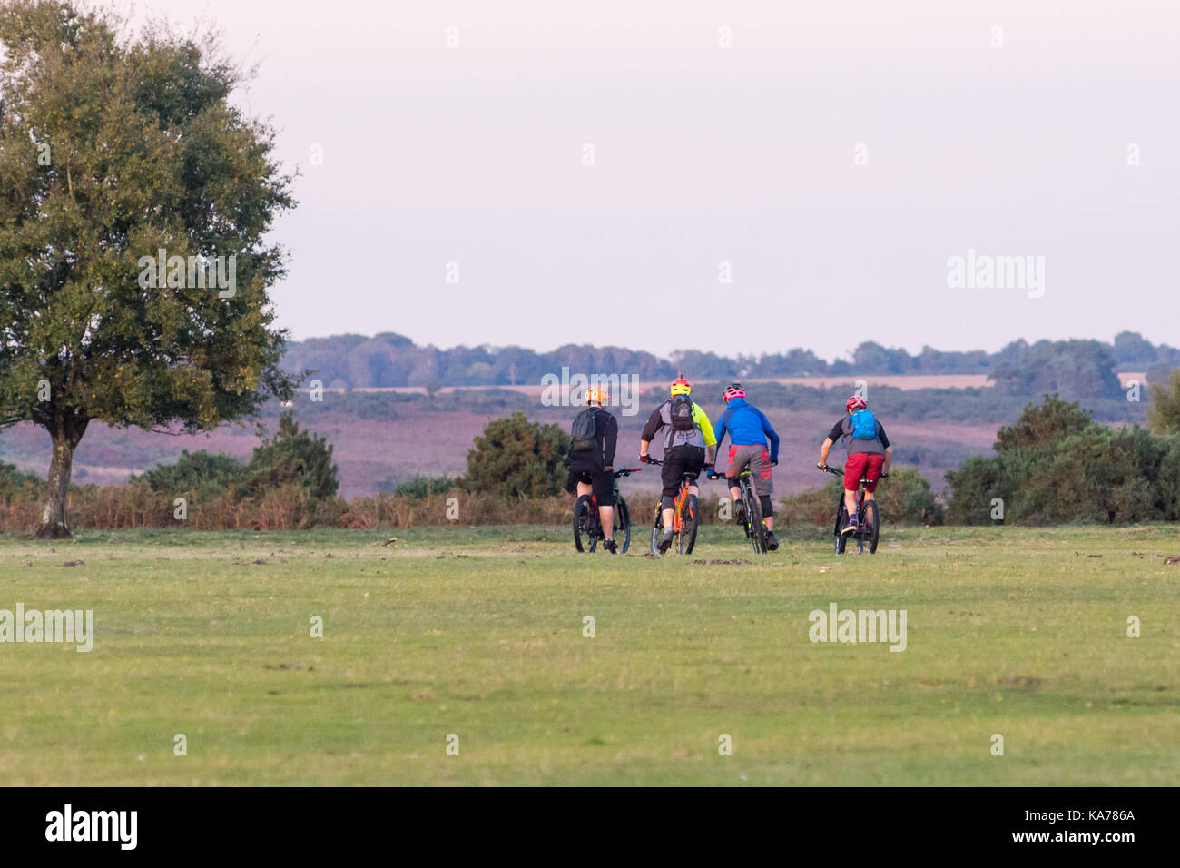 Four teenagers on mountain bikes heading off on a off road cross ...