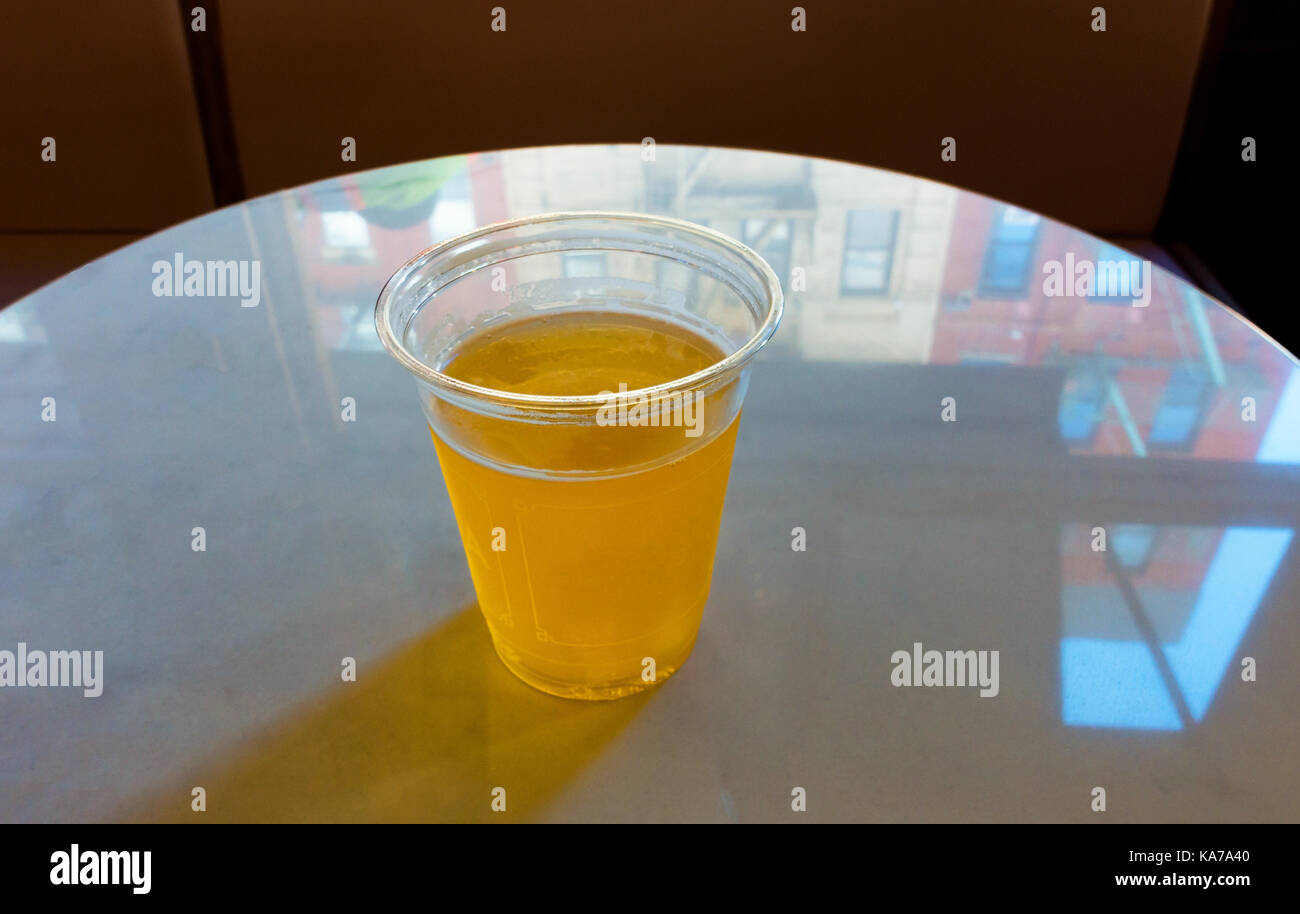 A plastic cup of cool larger beer on a round marble table Stock Photo ...