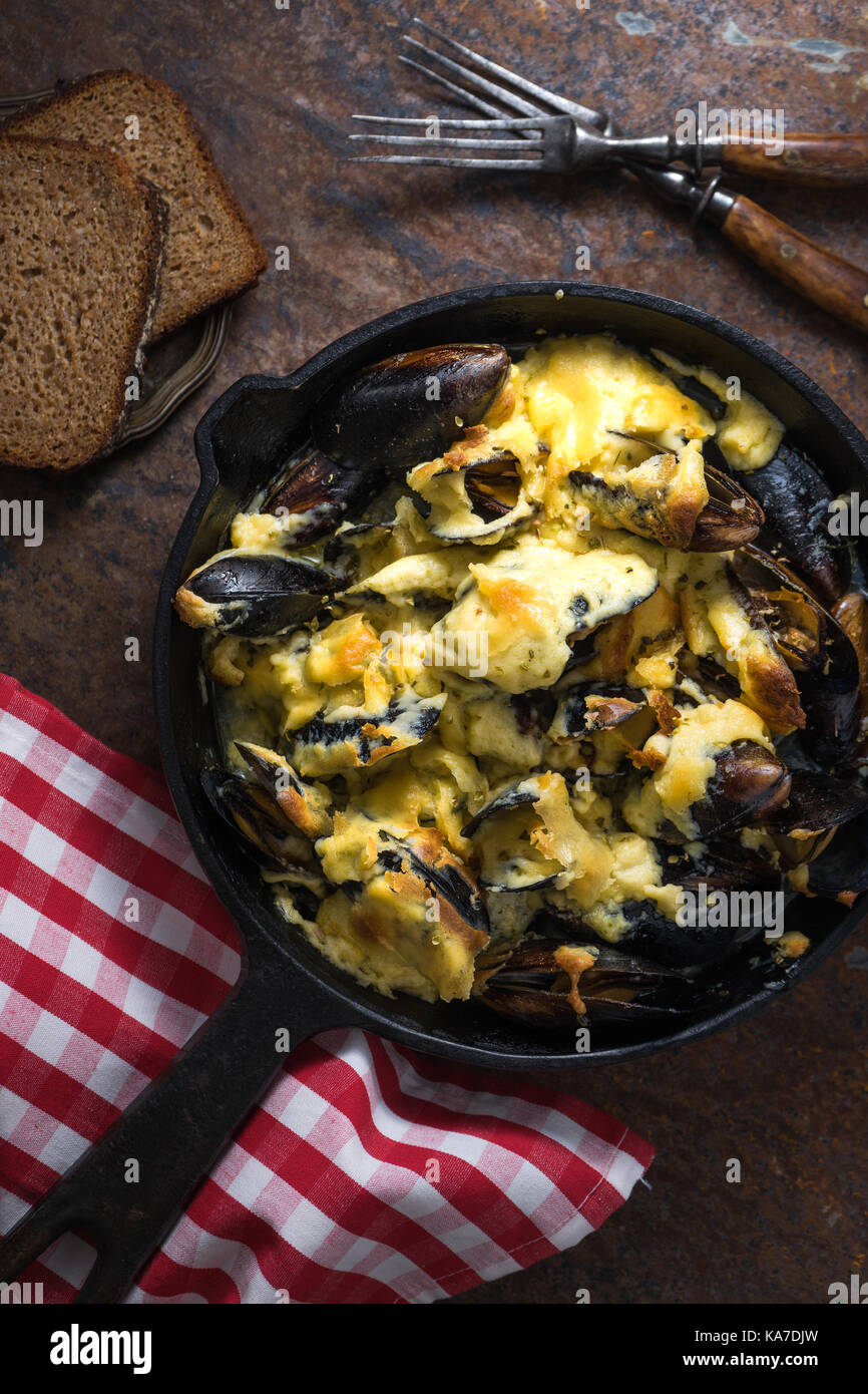Mussels with cheese sauce in a frying pan, napkin in a red cage ...