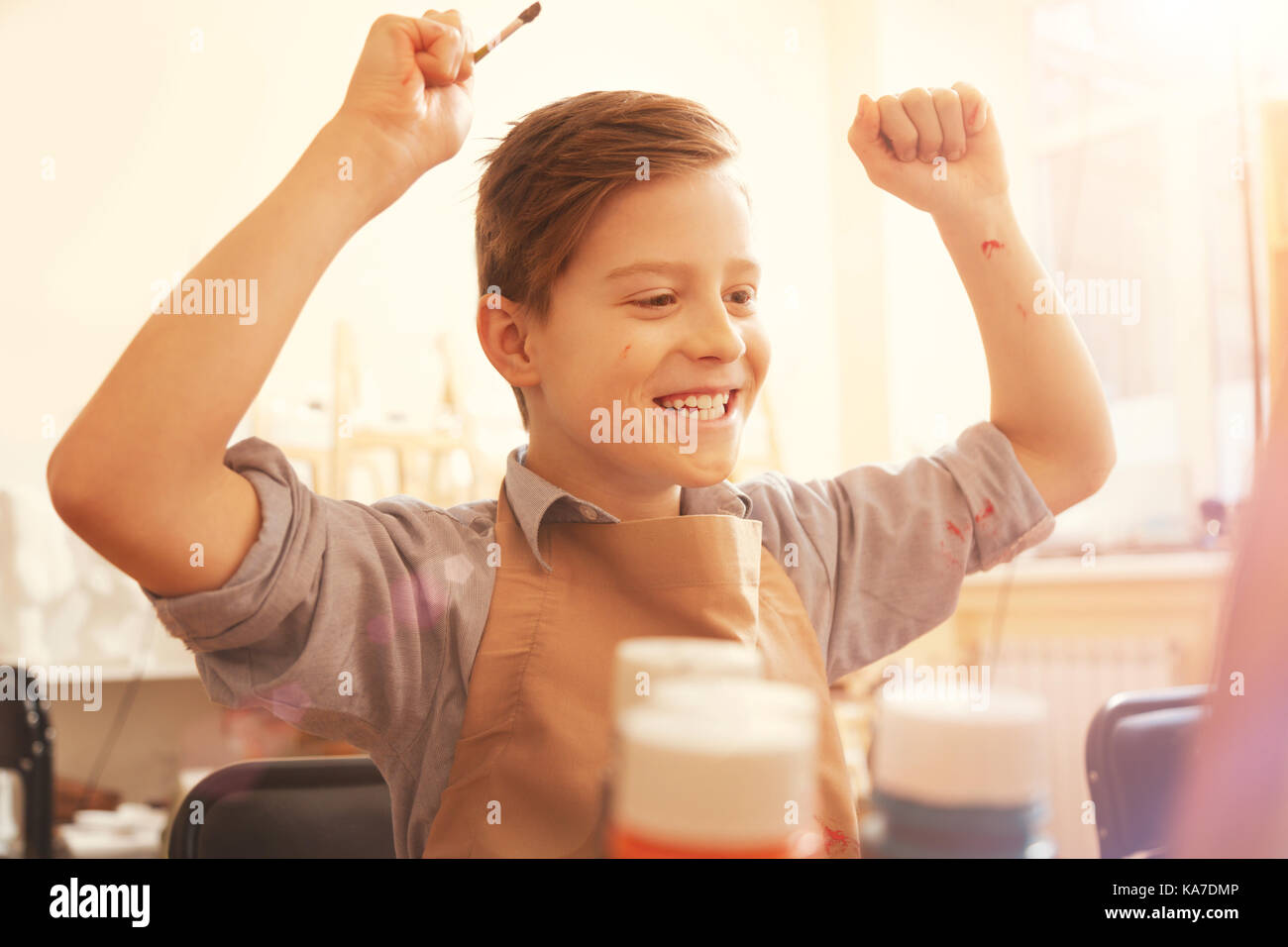 Excited young painter raising hands in air Stock Photo - Alamy