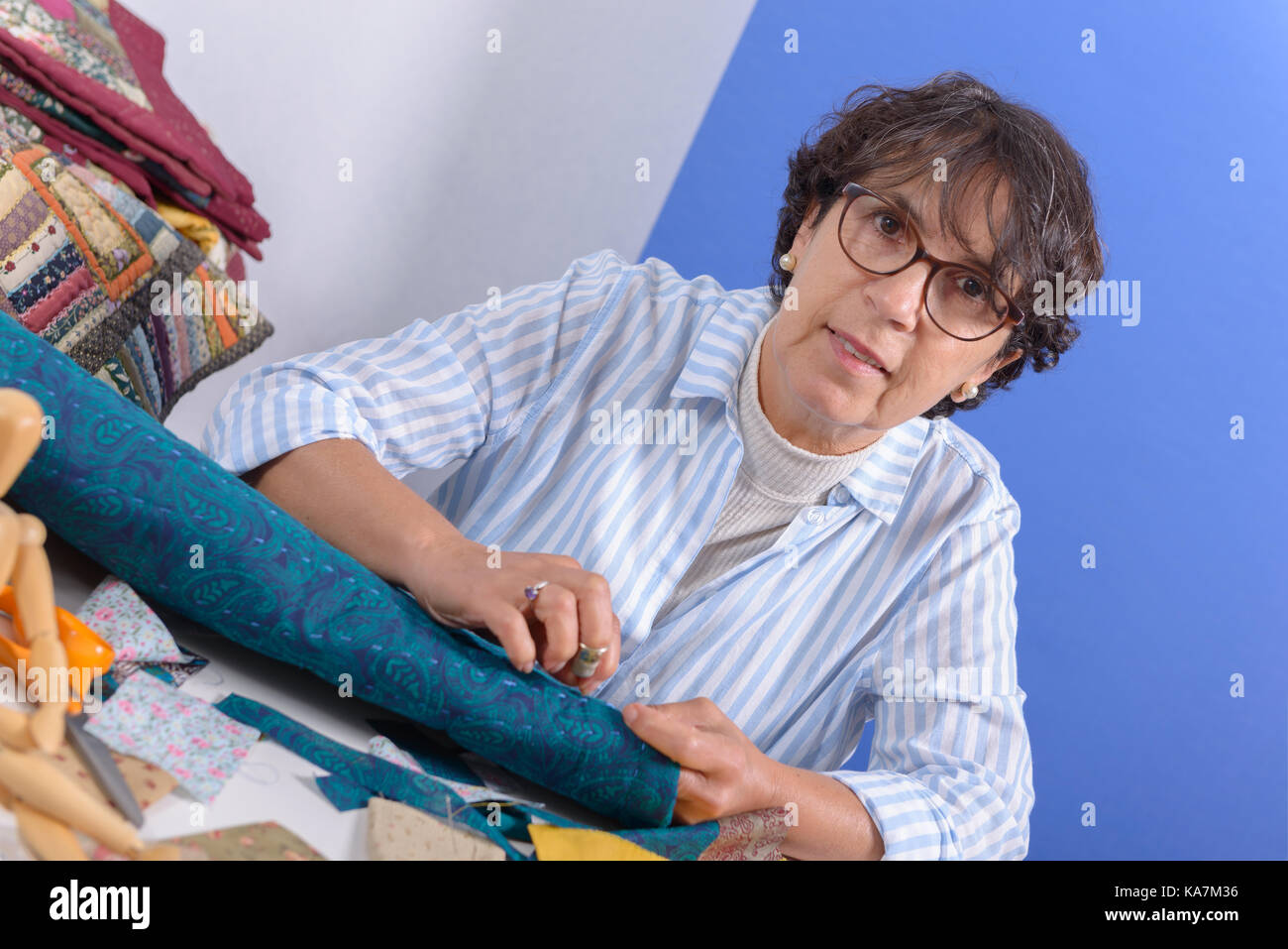 a pretty mature brunette woman sewing patchwork Stock Photo - Alamy
