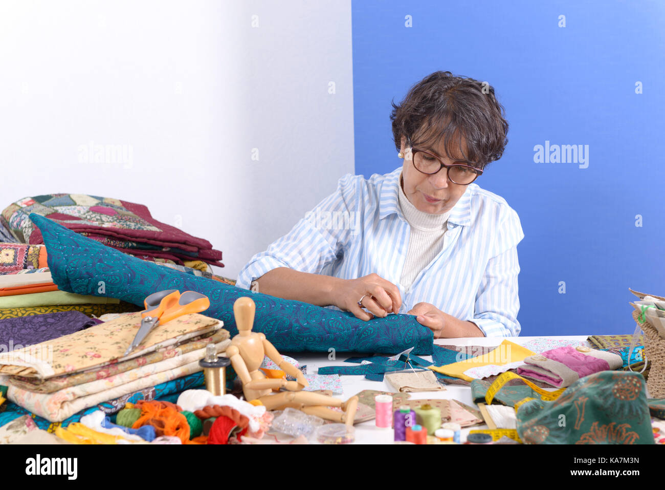 a pretty mature brunette woman sewing patchwork Stock Photo - Alamy