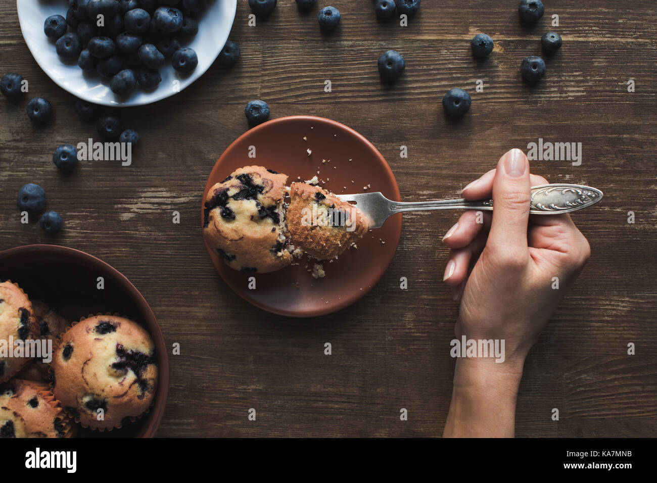 person eating muffin with blueberries Stock Photo - Alamy