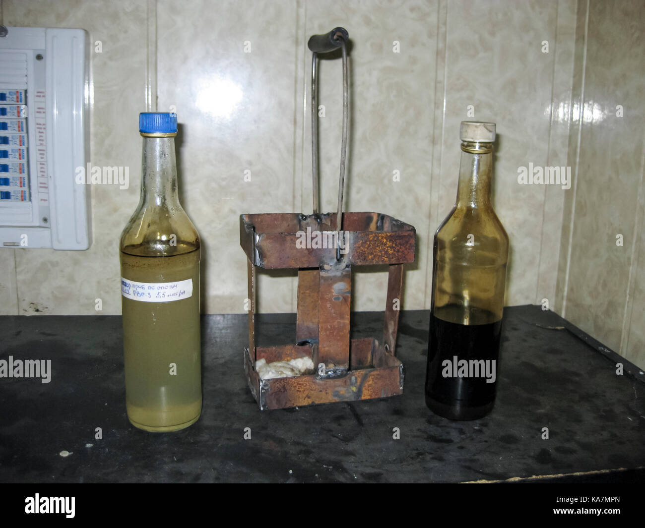A sample of oil and produced water next to the basket for carrying ...