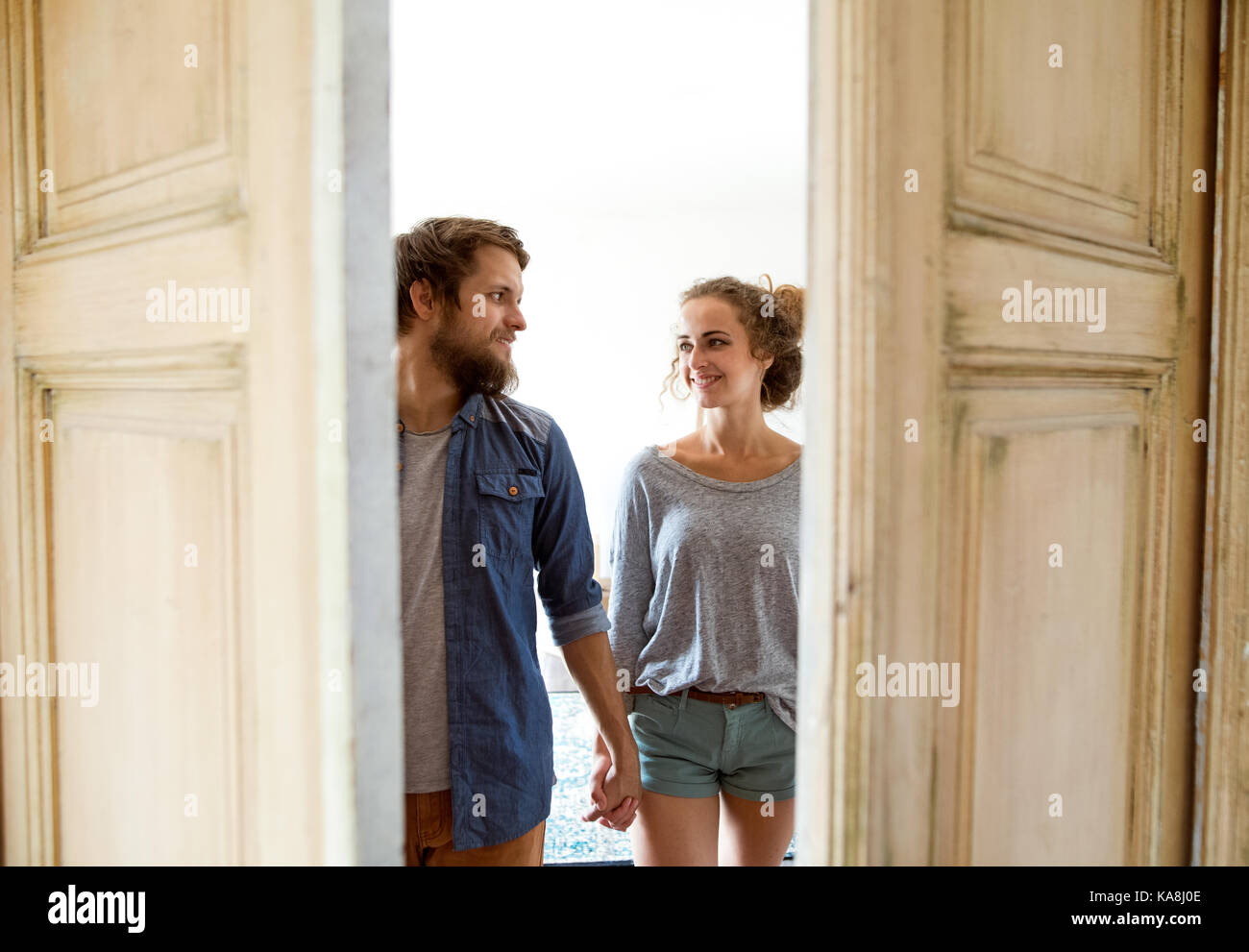 Couple moving in new house, entering through the door Stock Photo - Alamy