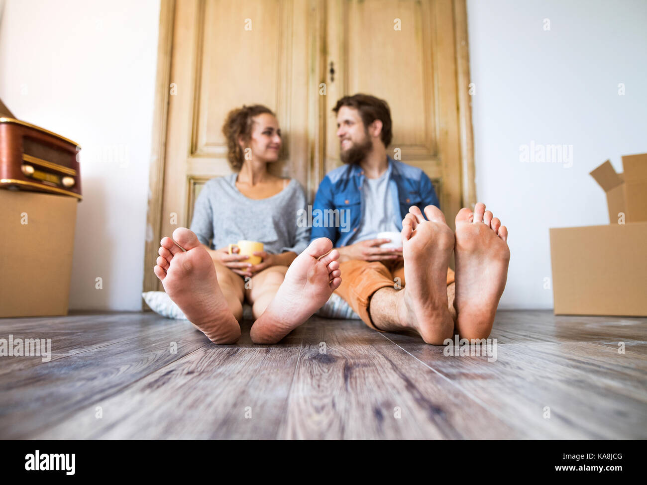 Young couple moving in new house, resting Stock Photo - Alamy