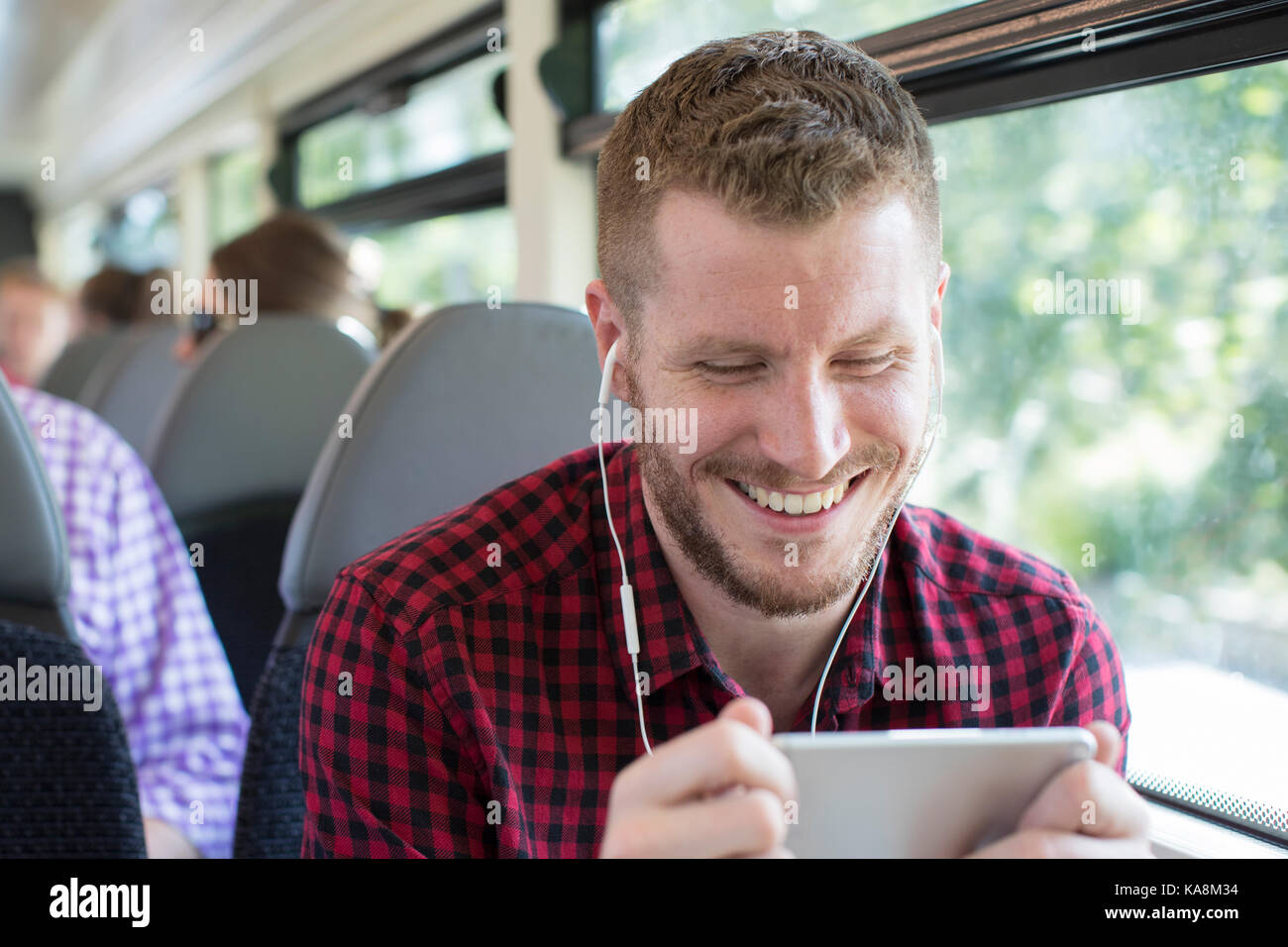 Man Watching Movie On Mobile Phone During Journey To Work Stock Photo ...