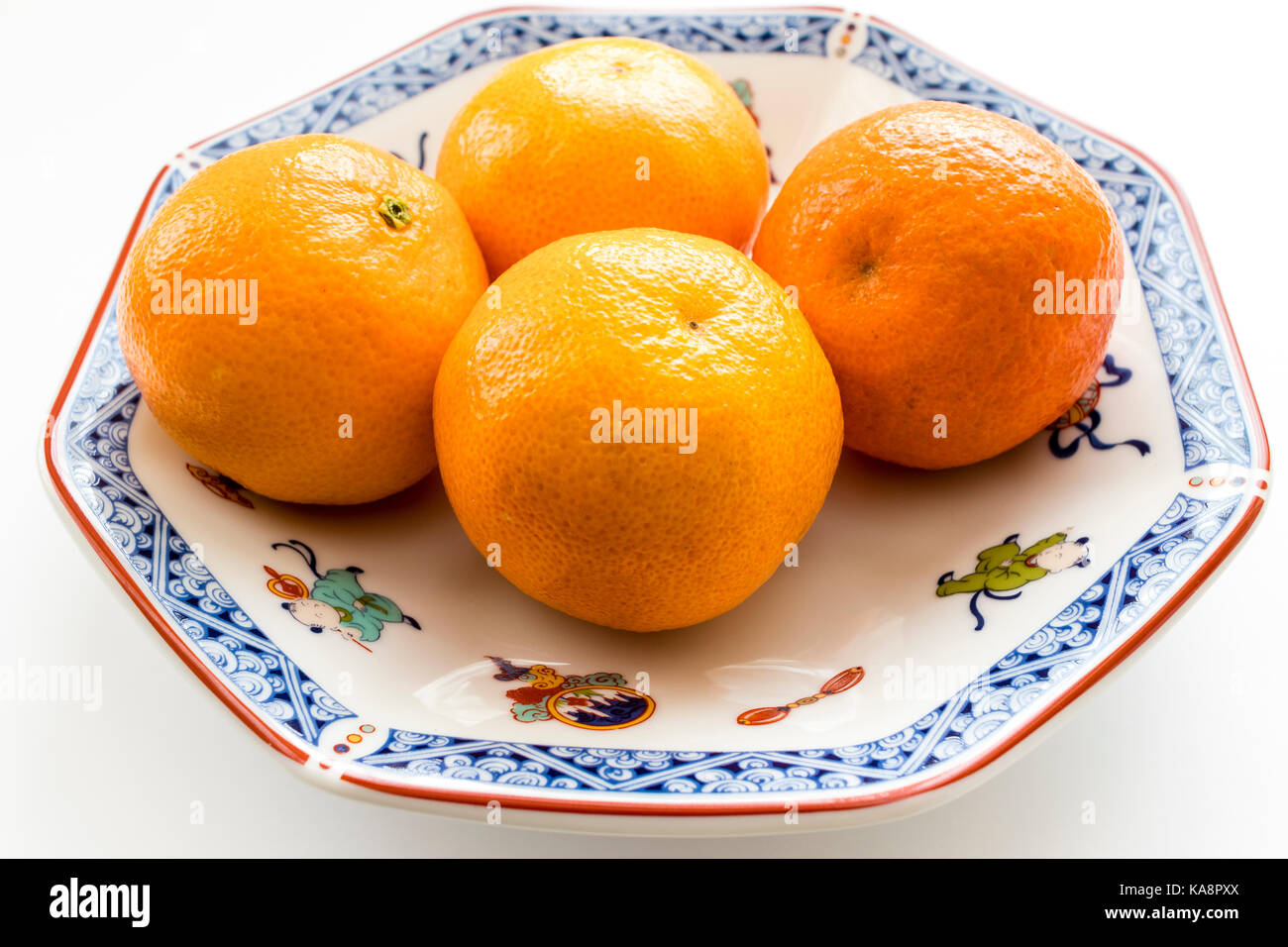 England. Fruit, four oranges on Chinese seven sided plate plate. Plain ...