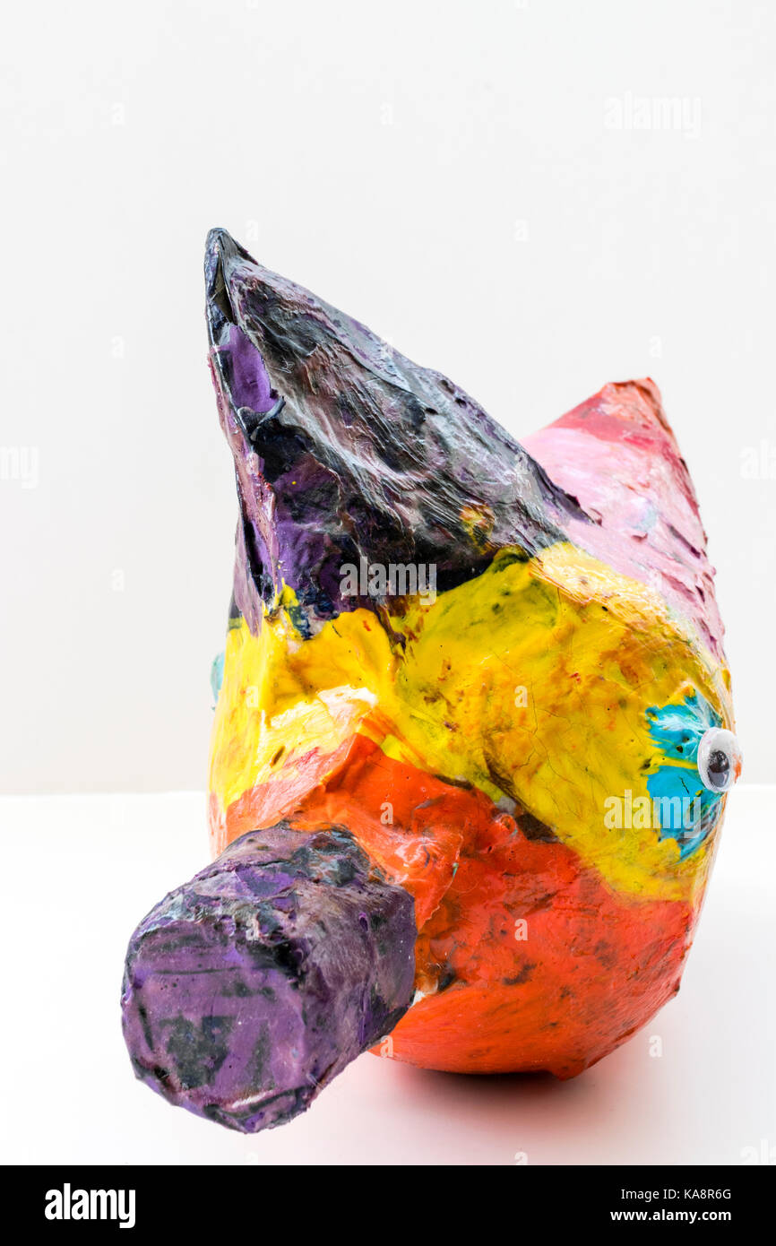 England. Child's creation, papier-mache fish multi-coloured on light ...