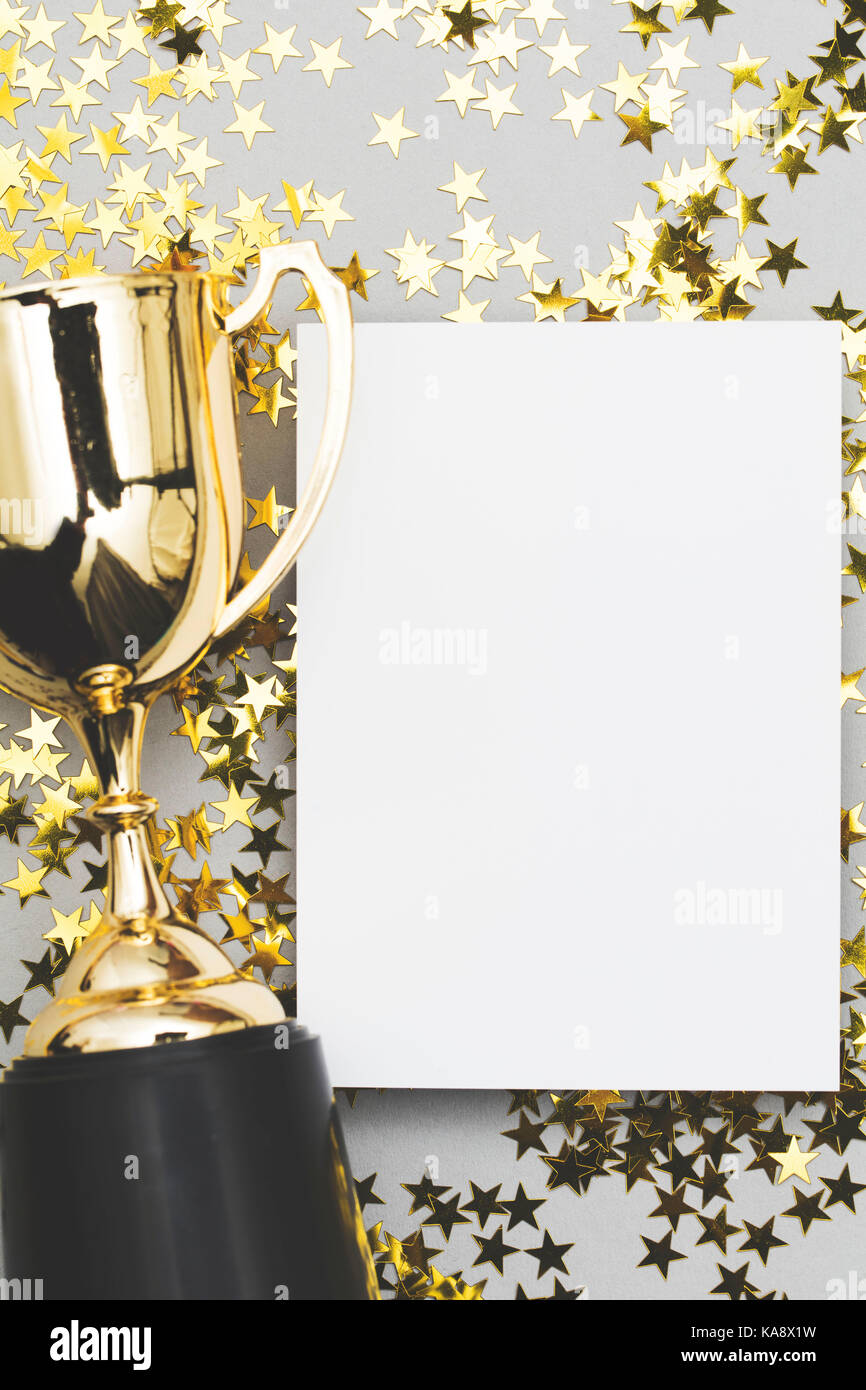 Gold winners trophy with a blank poster label and golden shiny stars ...