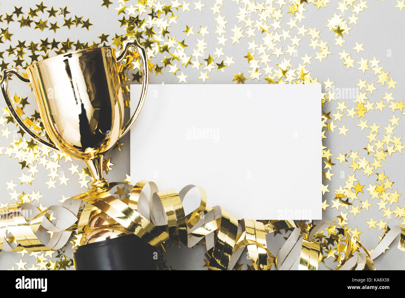 Gold winners trophy with a blank poster label and golden shiny stars ...