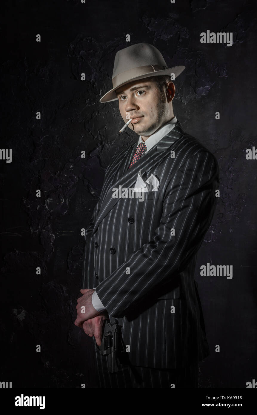 Private detective in old fashion hat smokes a cigarette. Gangster looks ...