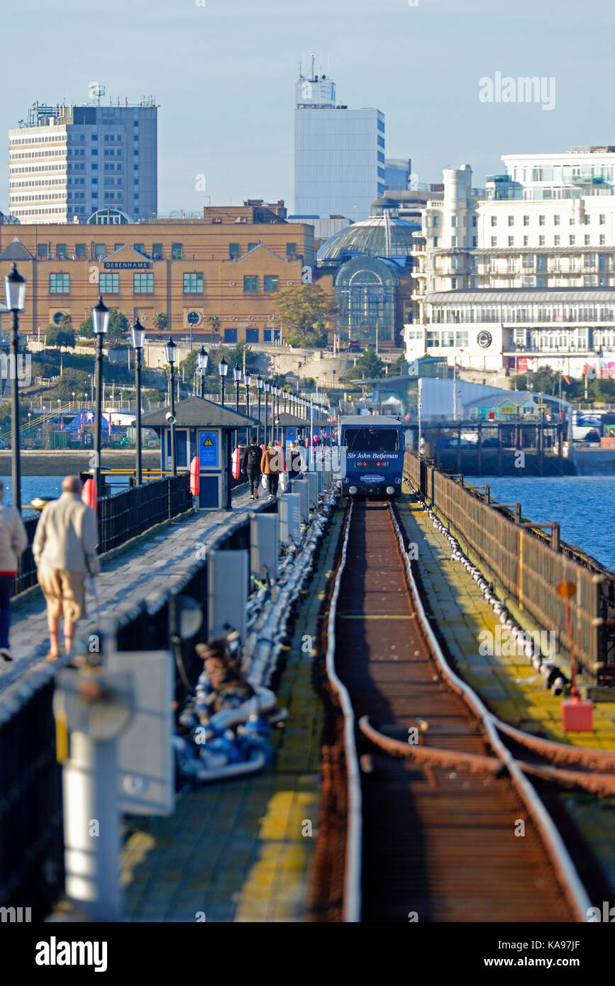 Southend Pier train and railway. Walkers on the walkway. Palace Hotel ...