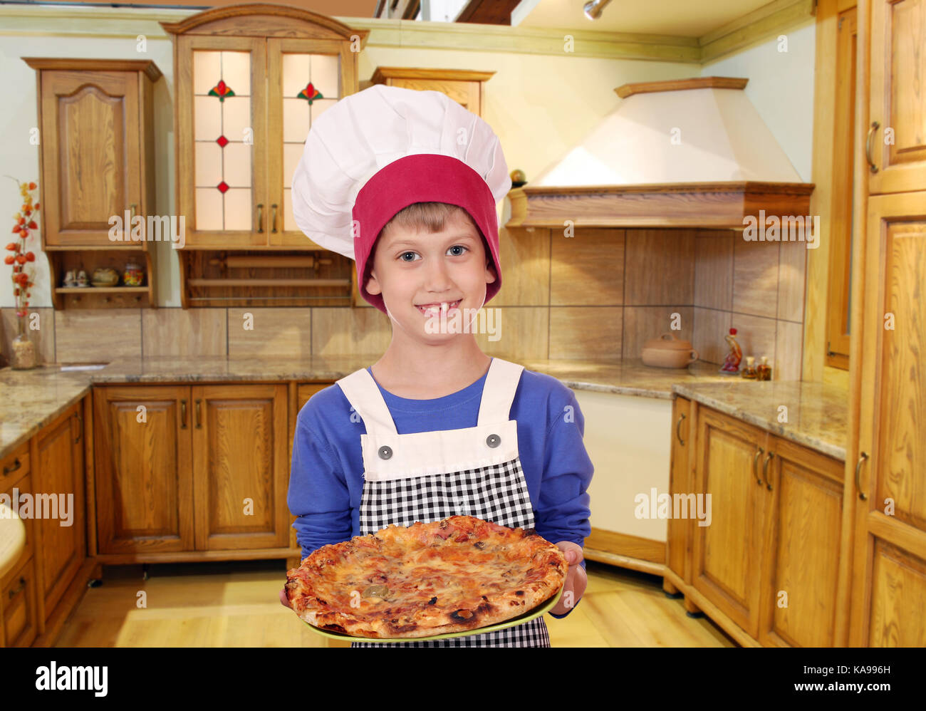 boy chef with pizza in kitchen Stock Photo - Alamy