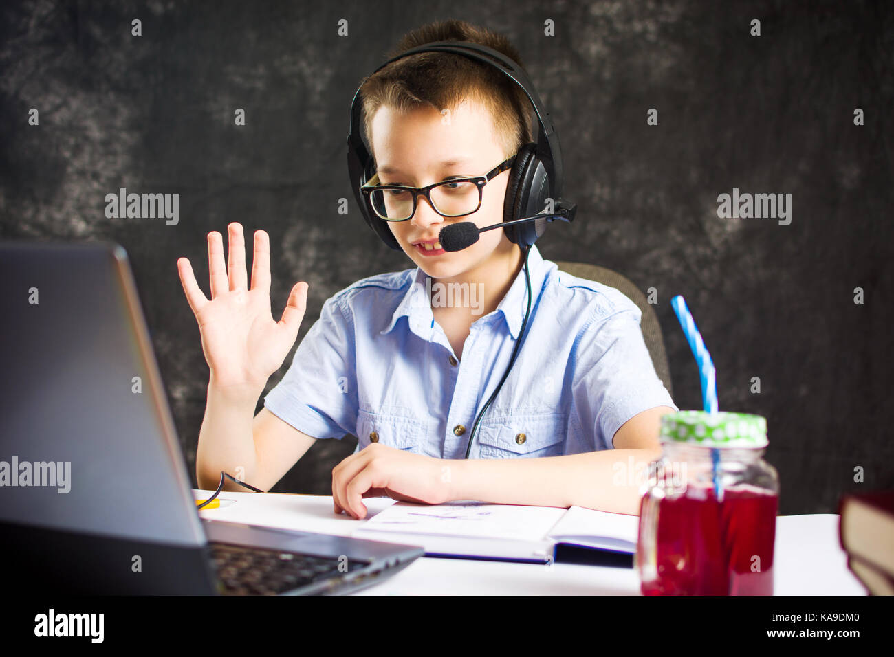 Teenage boy having a video call with headset Stock Photo - Alamy