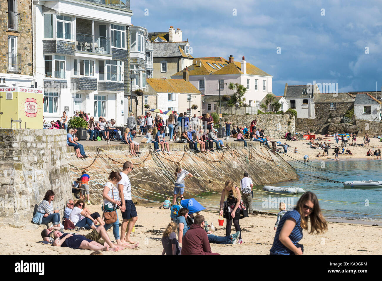 St Ives - holidaymakers relaxing on the harbourside and St Ives Harbour ...