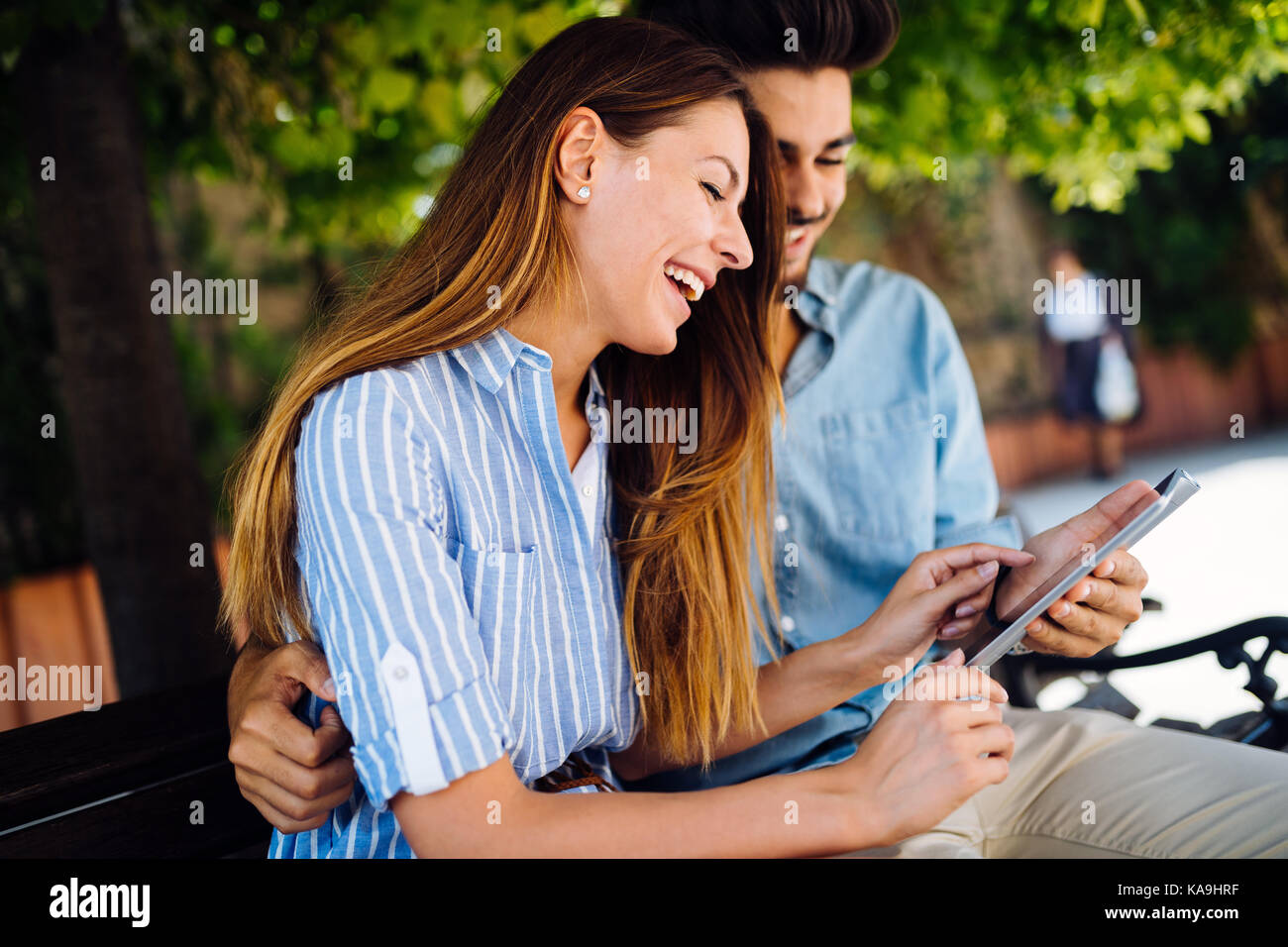 Young attractive couple on date sitting on bench Stock Photo - Alamy
