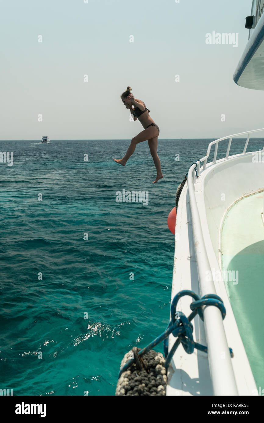 Girl jump into the water from the yacht Stock Photo - Alamy