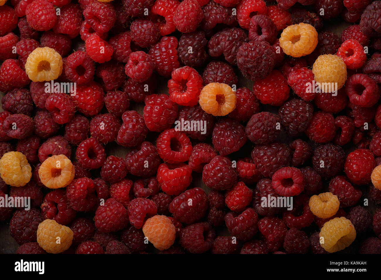 Red and yellow raspberry food background Stock Photo - Alamy