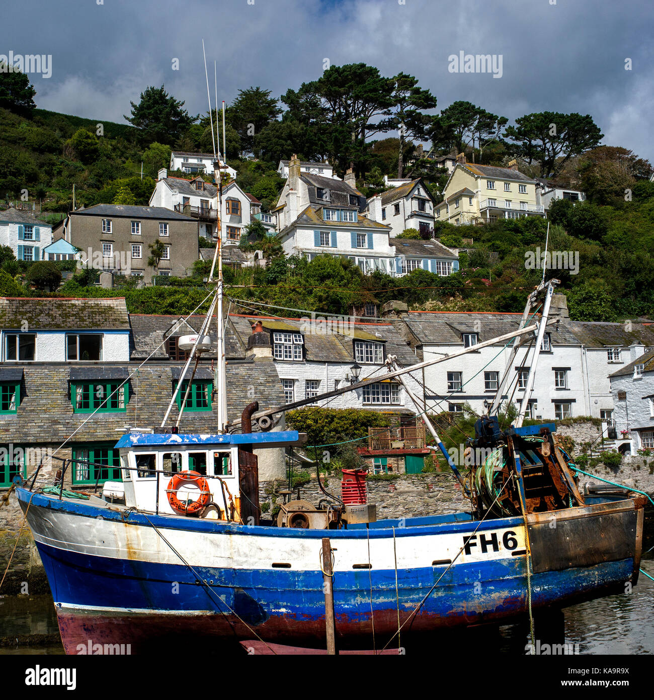 trawler in harbour with village behind Stock Photo - Alamy