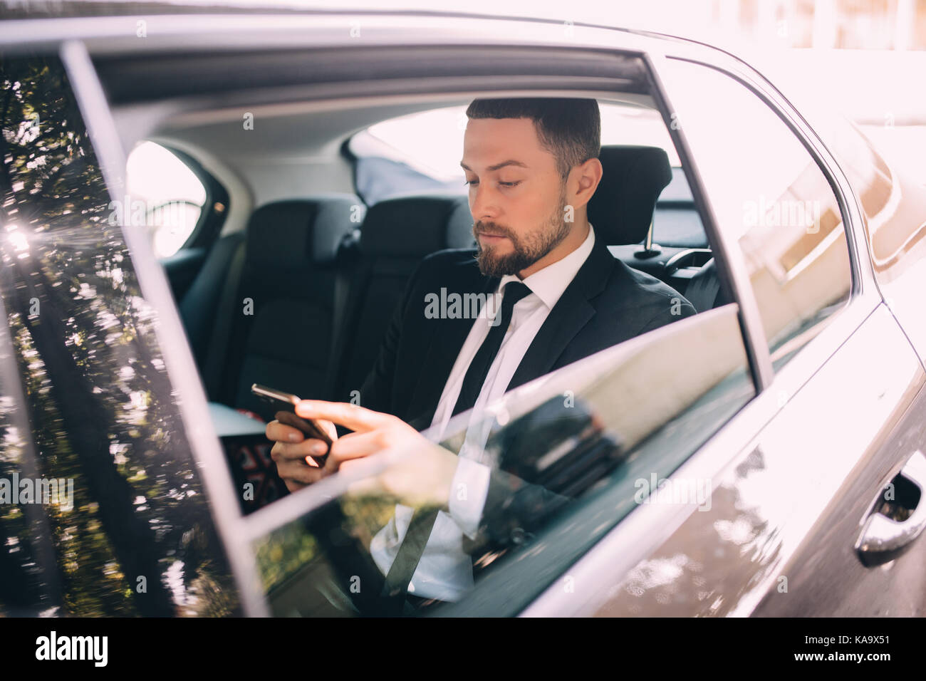Businessman talking on the mobile phone and looking outside the window ...