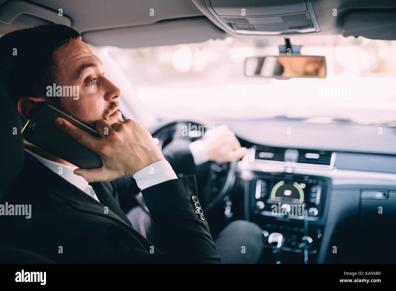 Man using his phone while driving the car Stock Photo - Alamy