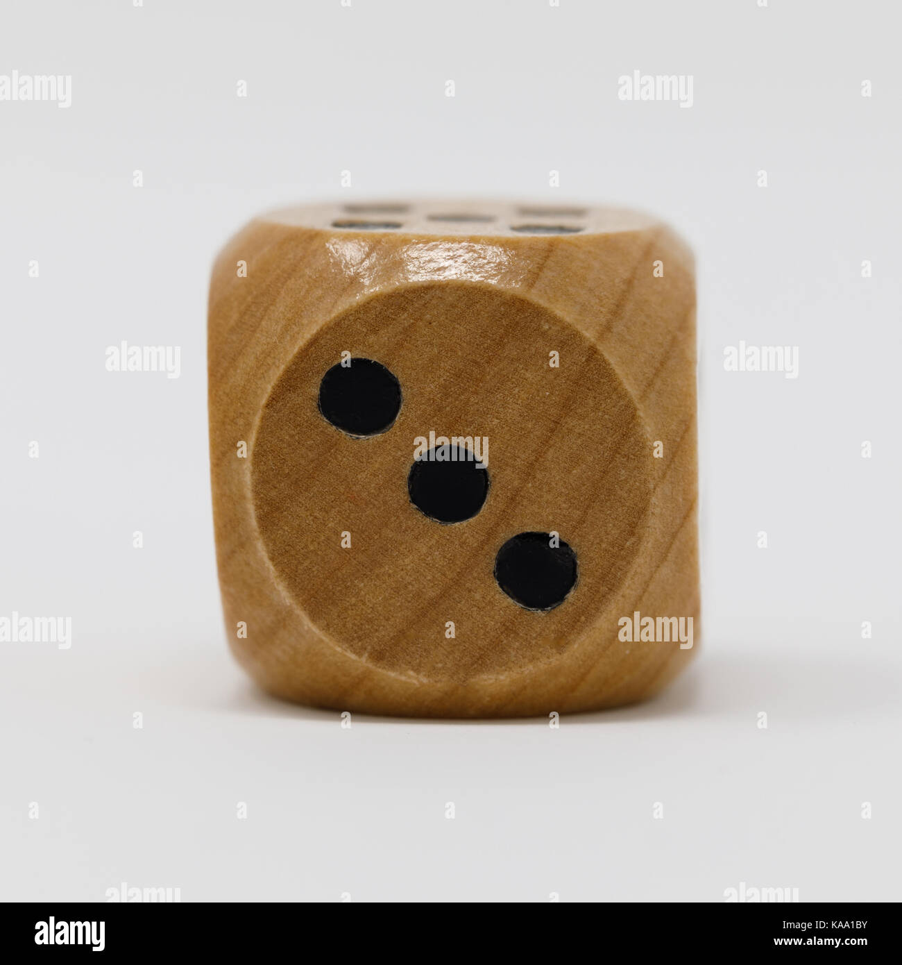 First in a sequence of real wooden dice - 3 spot die Stock Photo - Alamy