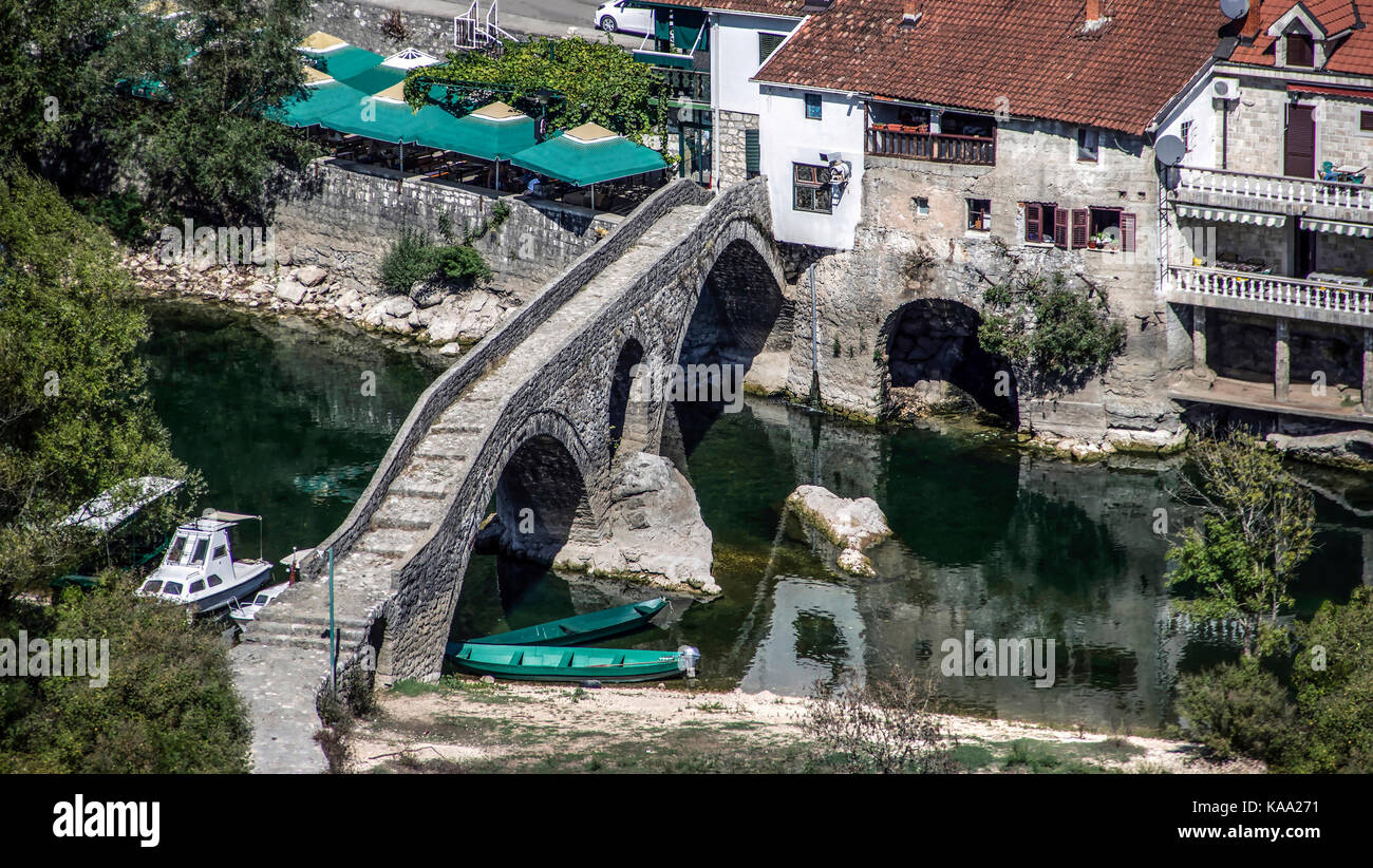 Montenegro - The ancient triple arched bridge in the old town of Rijeka Crnojevica spanning the ...