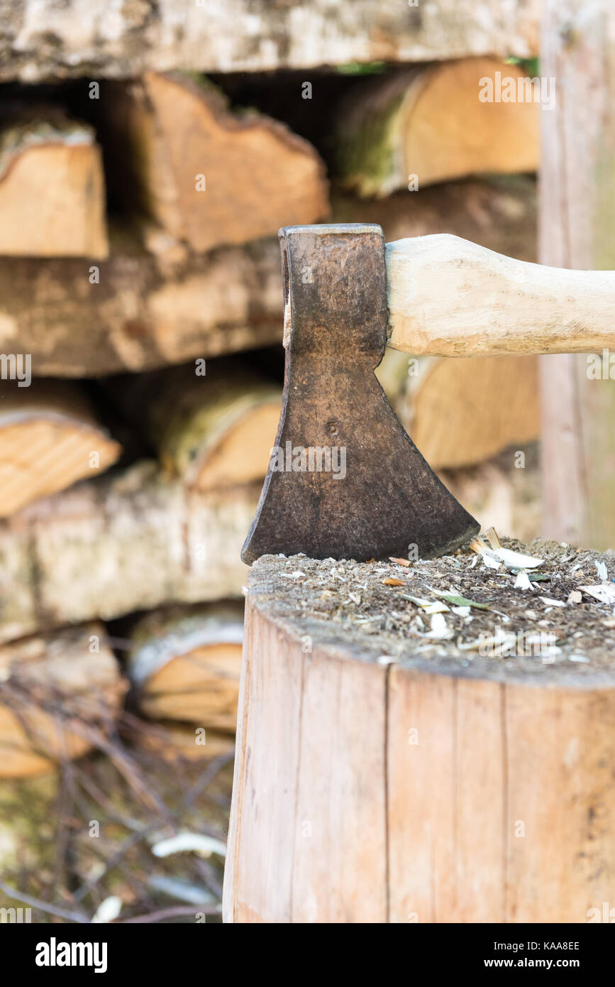 Ax of lumberjack in front of stacked logs Stock Photo - Alamy