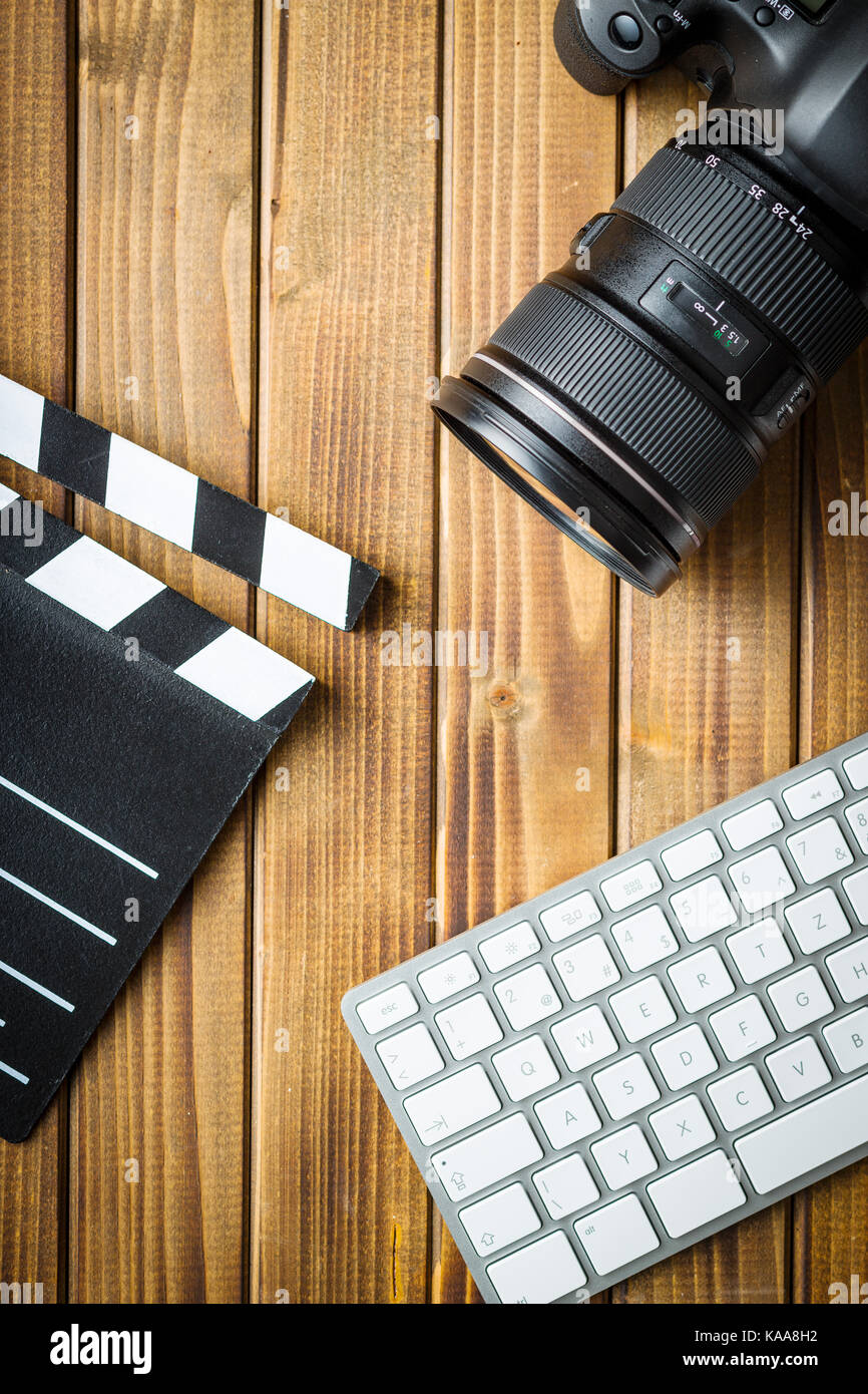 Professional camera,computer keyboard and clapper board on wooden table ...