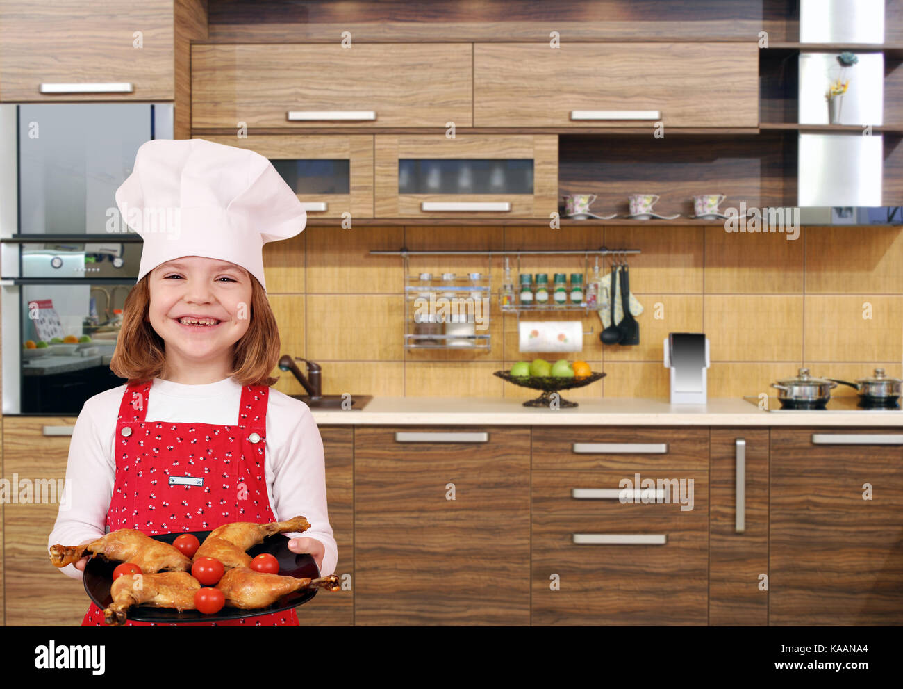 little girl cook with chicken drumstick in kitchen Stock Photo - Alamy