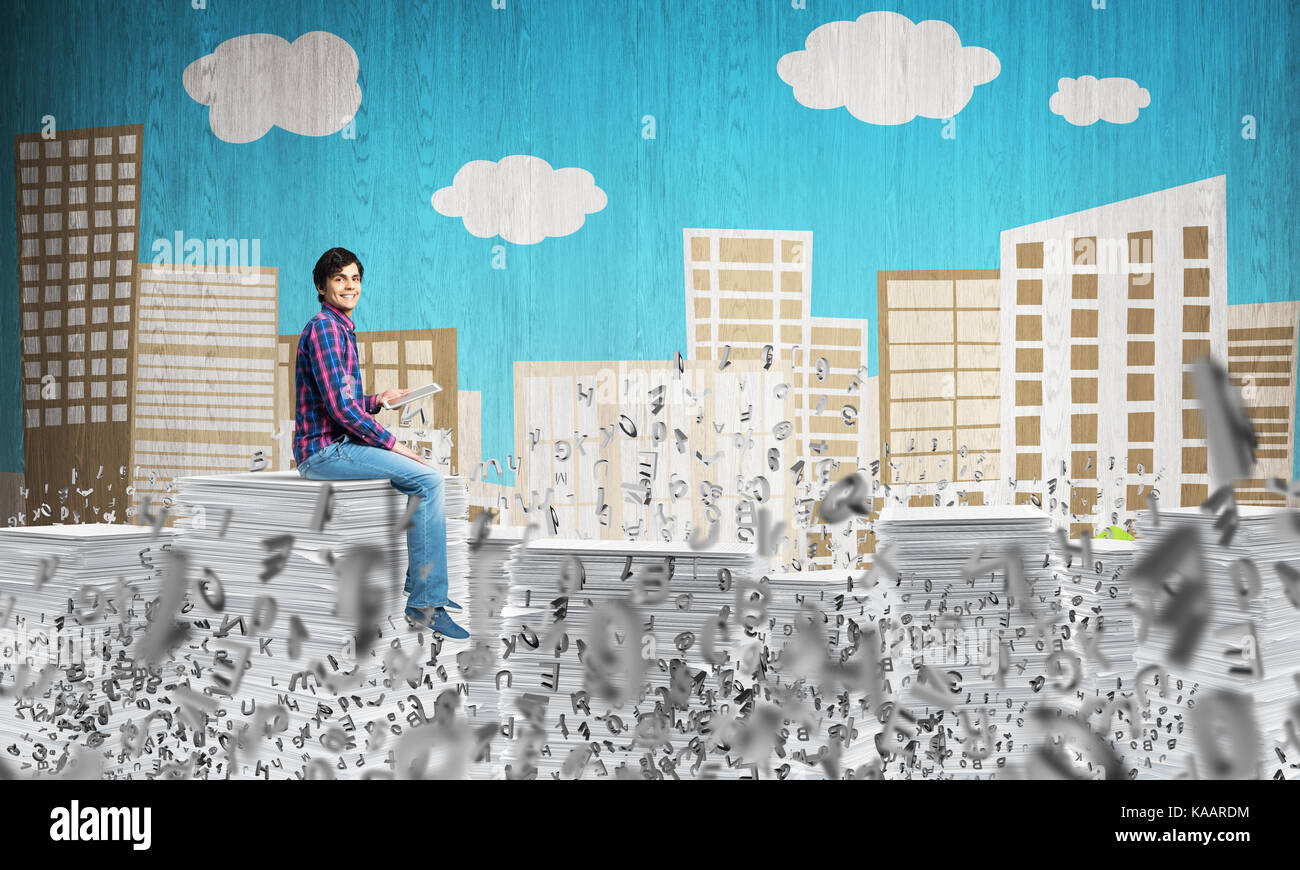 Young man sitting on pile of paper documents Stock Photo - Alamy