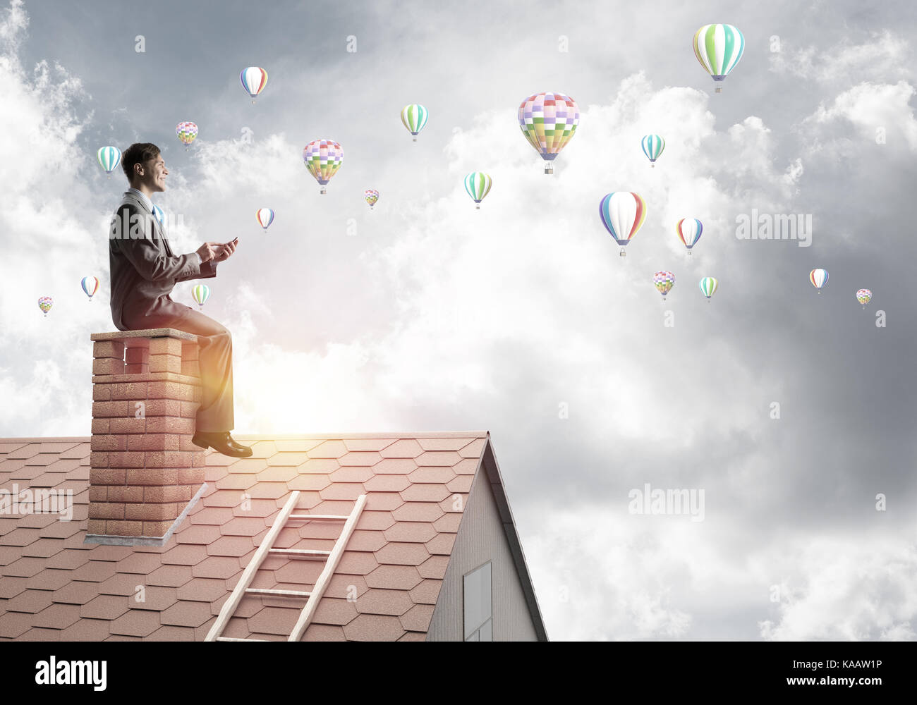 Man on brick roof using smartphone and aerostats flying in air Stock ...