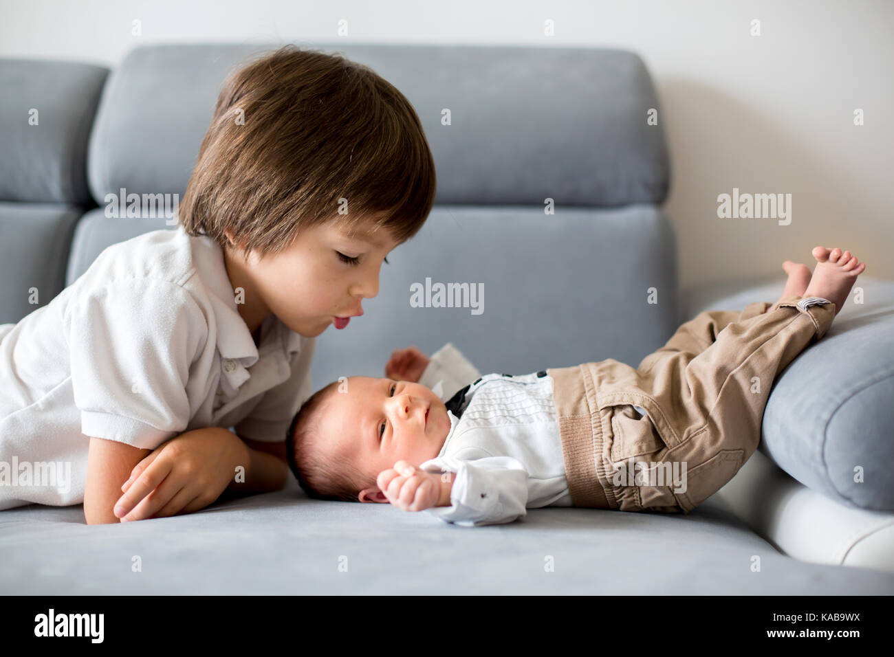 Sweet preschool boy, hugging with tenderness and care his little ...