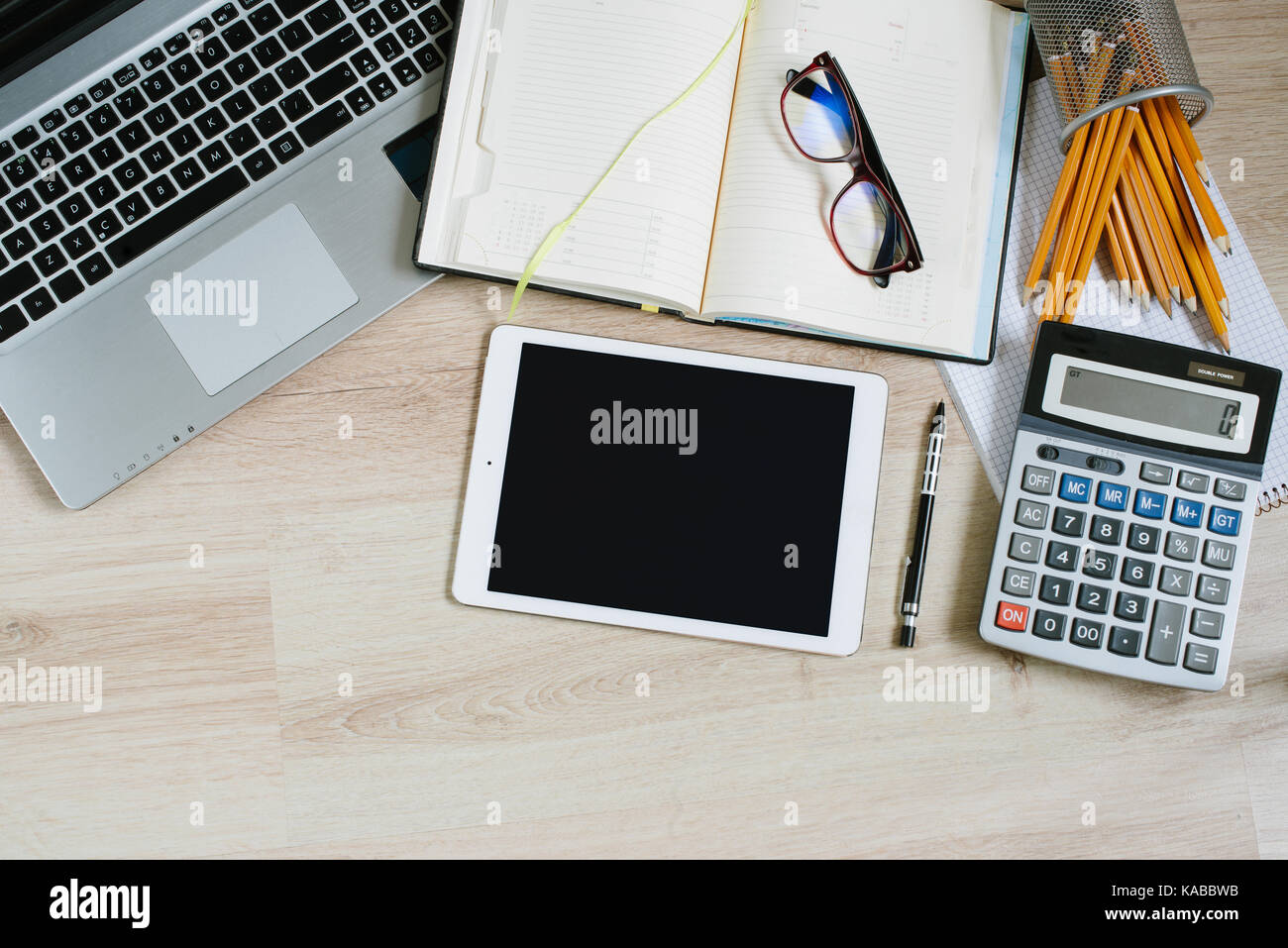 Work office desk table with laptop, tablet, supplies and calculator ...