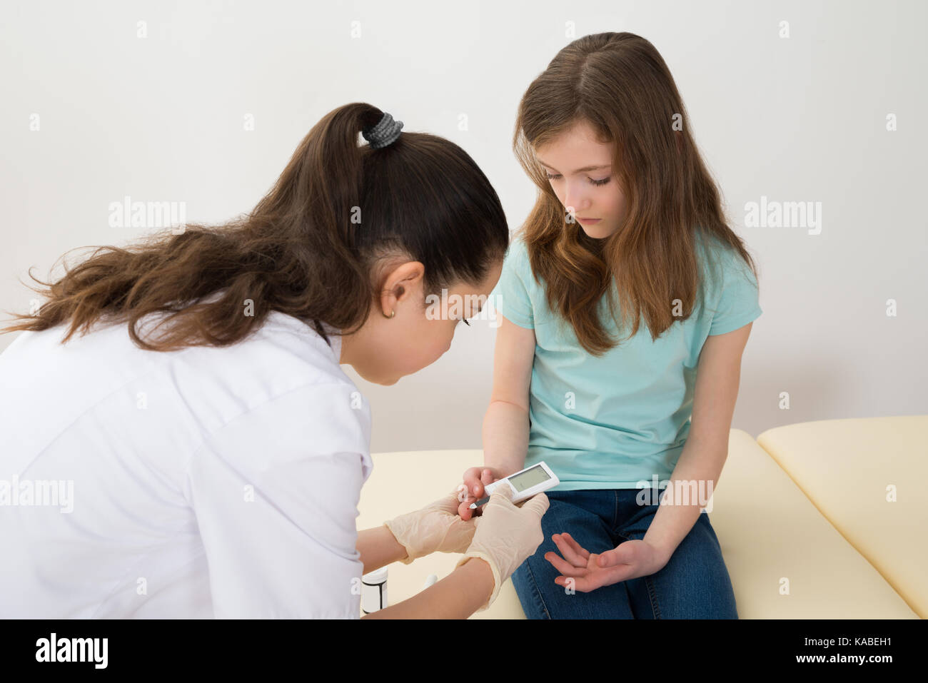 Doctor In Labcoat Measuring Blood Sugar Level Of Girl With Glucometer ...