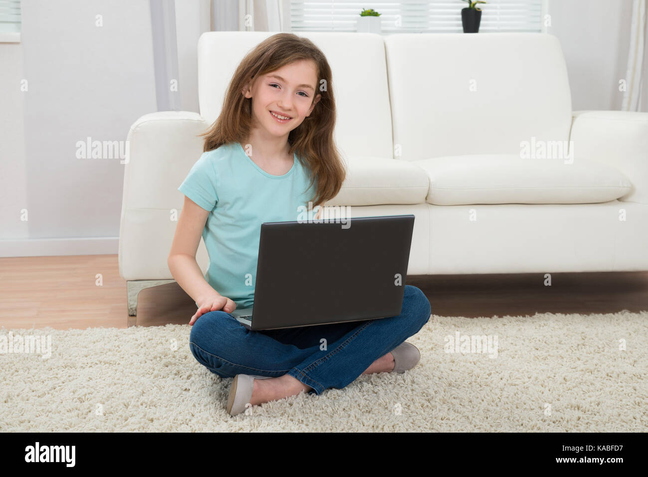 Happy child girl sitting sofa hi-res stock photography and images - Alamy