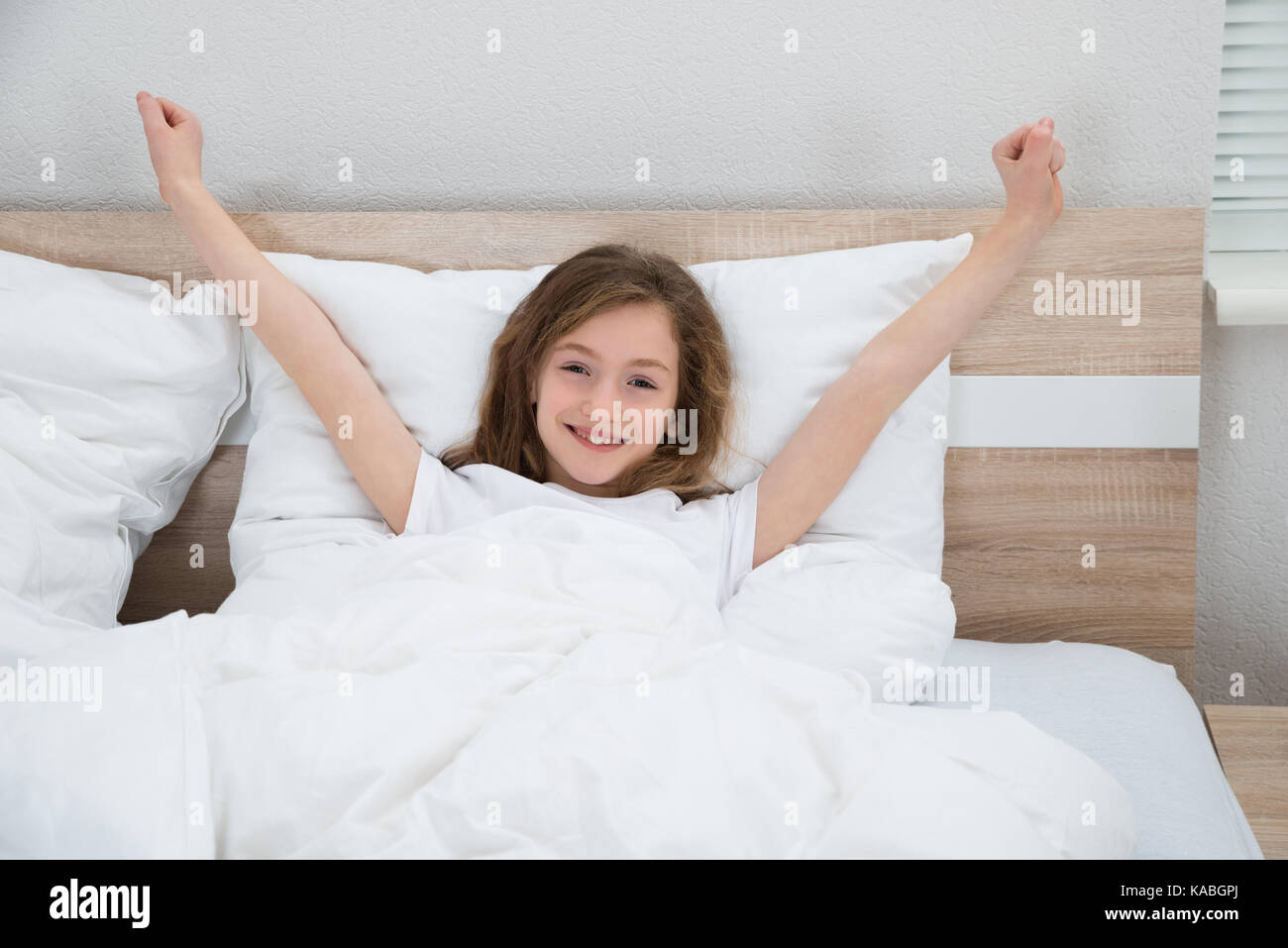 Girl Smiling While Waking Up From Bed Stock Photo - Alamy