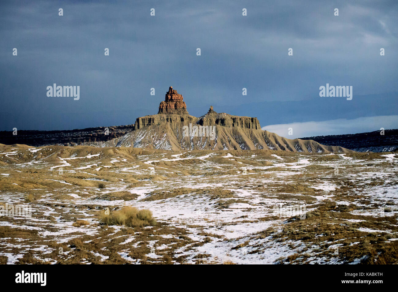 A snow covered plain leading up to a vertical rock formation Stock ...