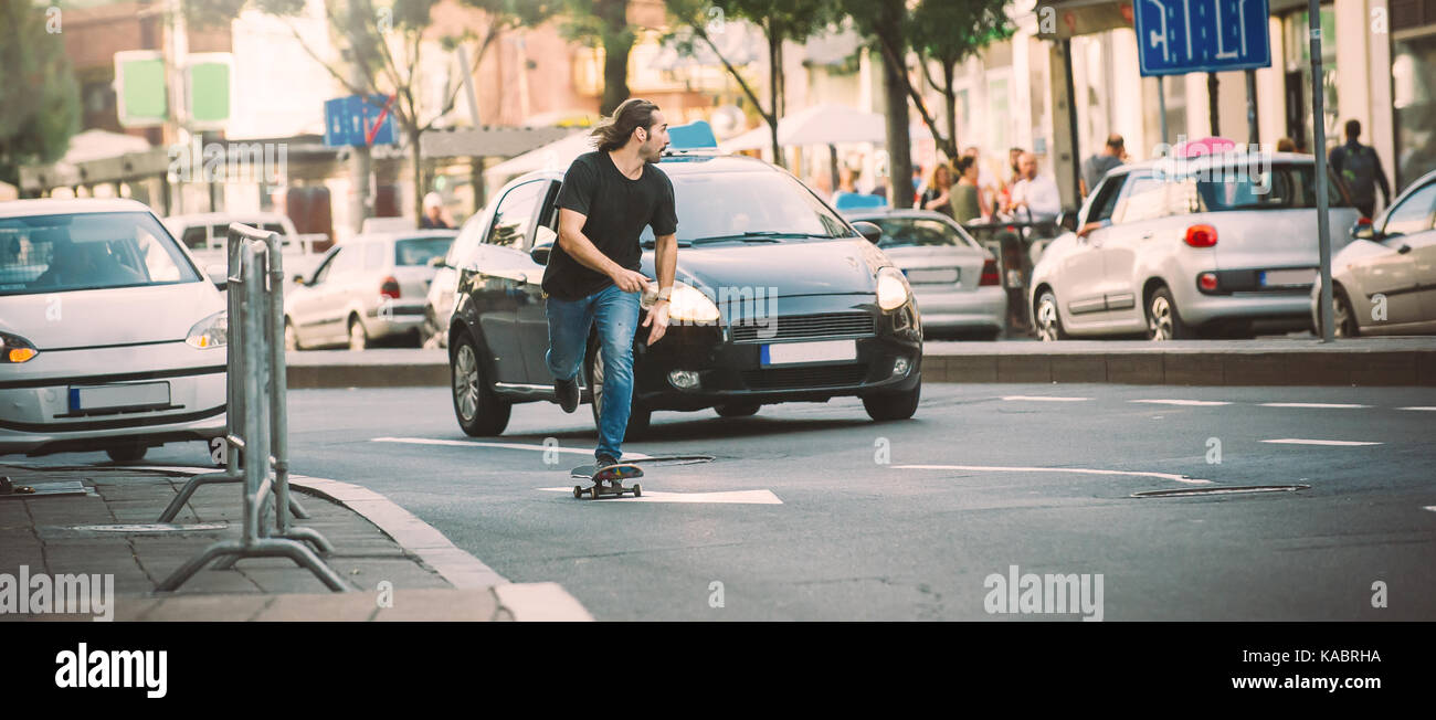 Professional skater riding skate on the main streets through cars and ...