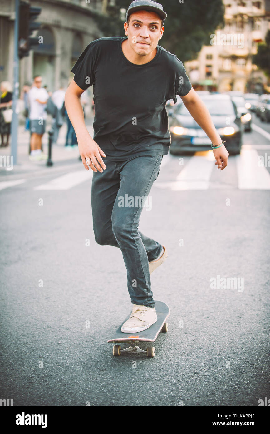 Professional skater riding skate on the main streets through cars and ...