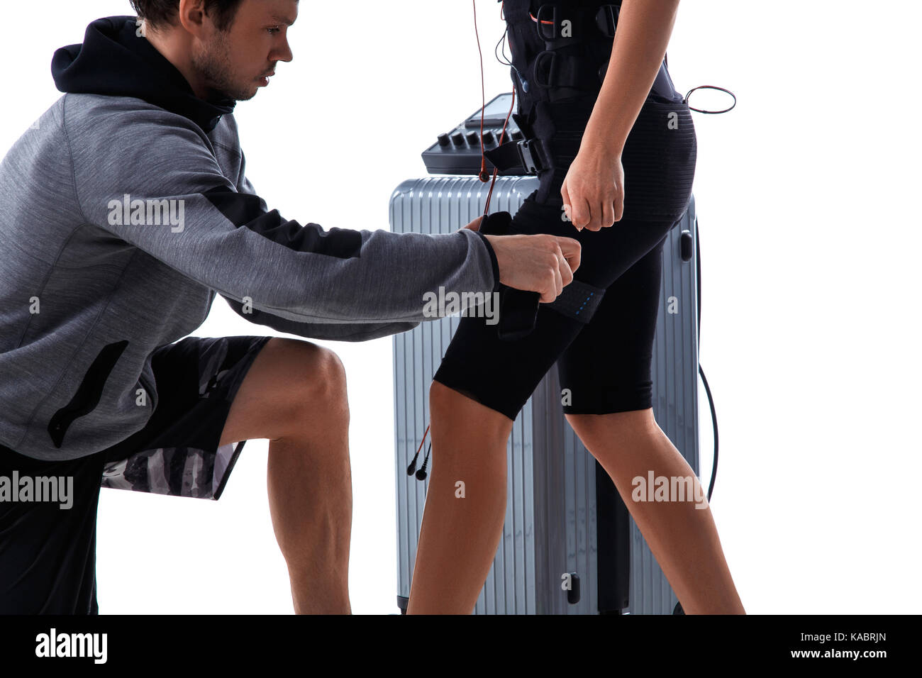 Trainer helps woman attaching electrode on ems suit, isolated on white ...