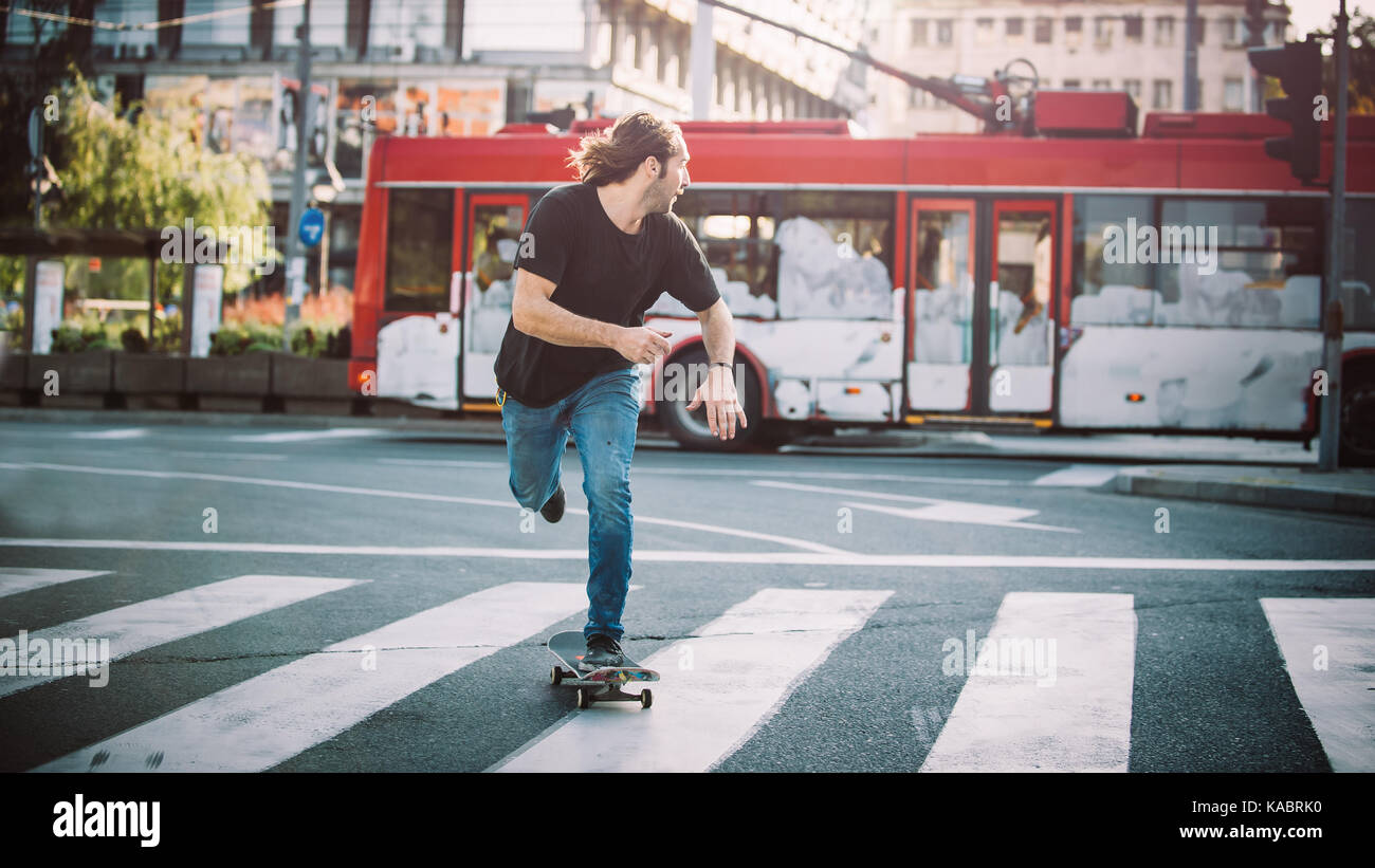 Professional skater riding skate on the main streets through cars and ...