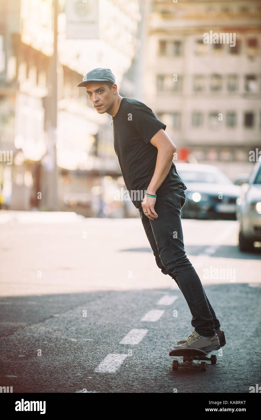Professional skater riding skate on the main streets through cars and ...