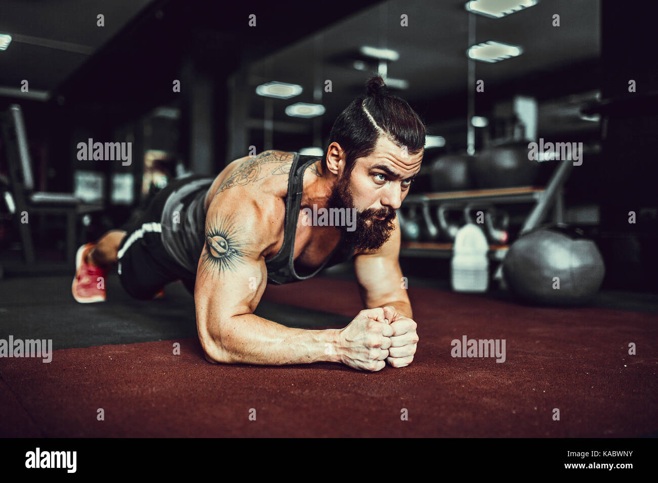 Muscled young man wearing sport wear and doing plank position while ...