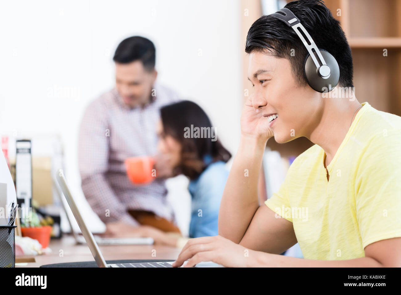 Young Asian employee watching a video presentation on laptop in Stock ...