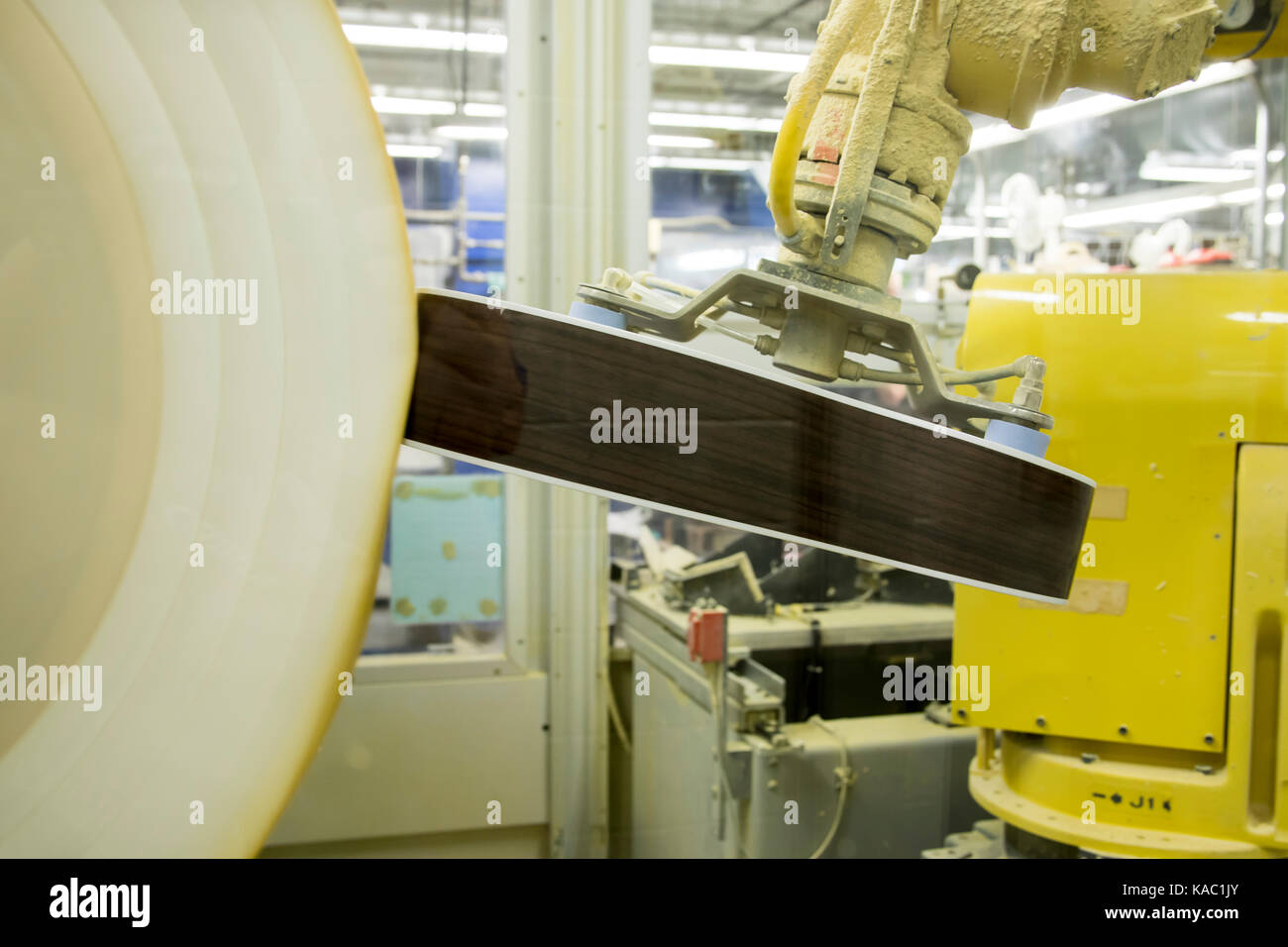Robotic arm in and buffing equipment in guitar factory Stock Photo - Alamy