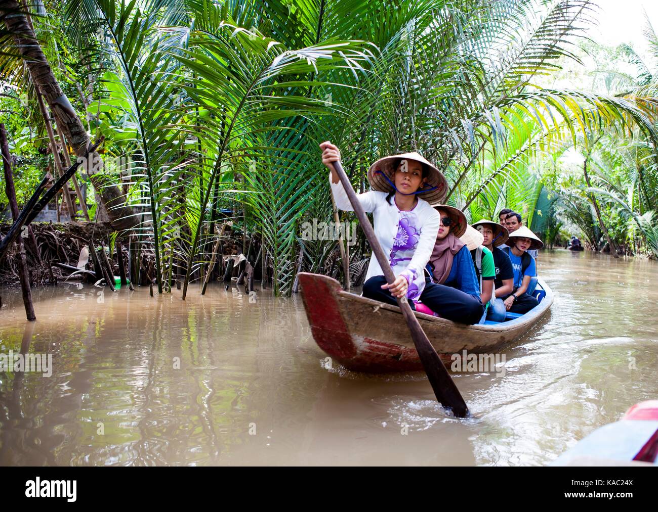 Vietnamese woman rowing a boat in Mekong River in Vietnam Stock Photo ...