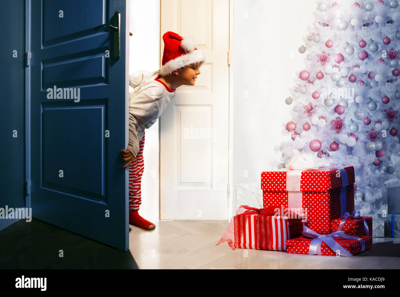 Boy checking presents under Christmas tree Stock Photo - Alamy